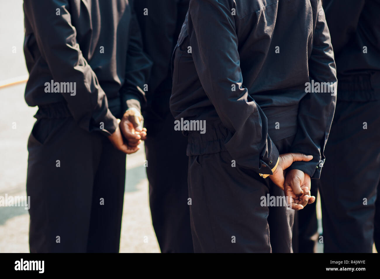 Legs police men guard on the construction rear view dark hands. African ...