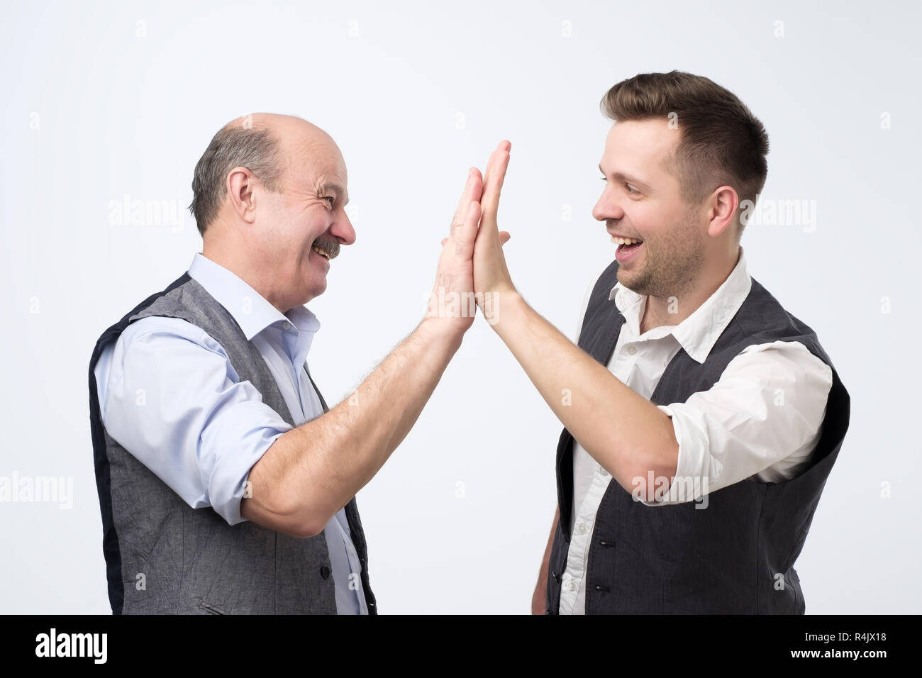 Two cheerful business men clapping each other hands and smiling Stock ...