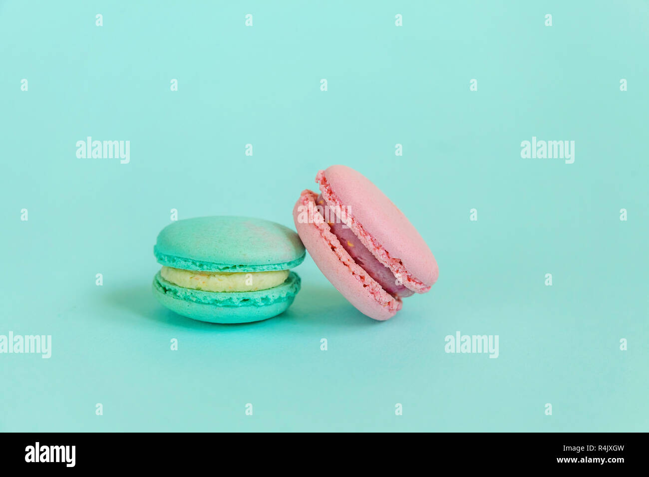 Sweet almond colorful pink blue macaron or macaroon dessert cake isolated on trendy blue pastel ...