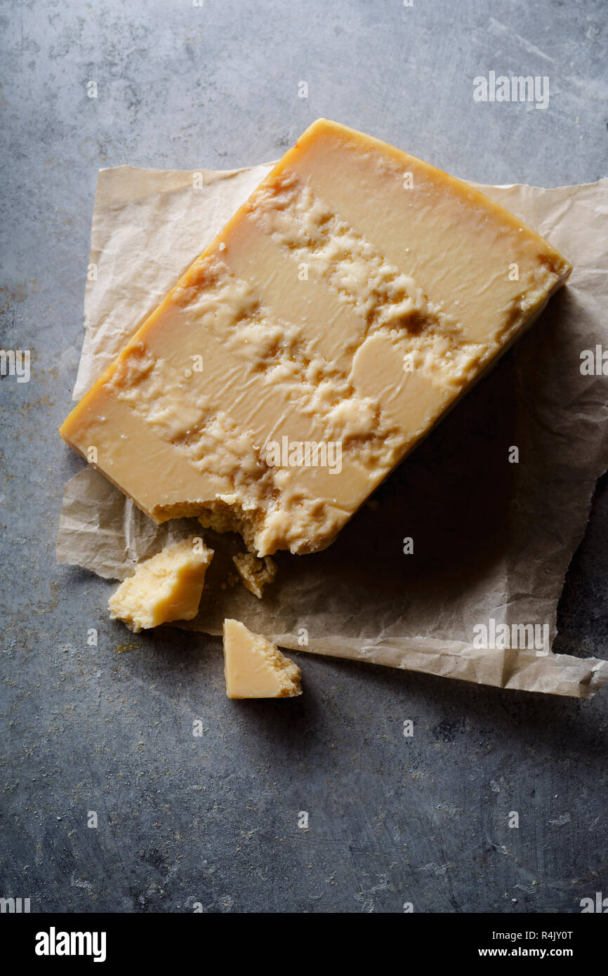 A block of parmesan cheese on parchment paper Stock Photo - Alamy
