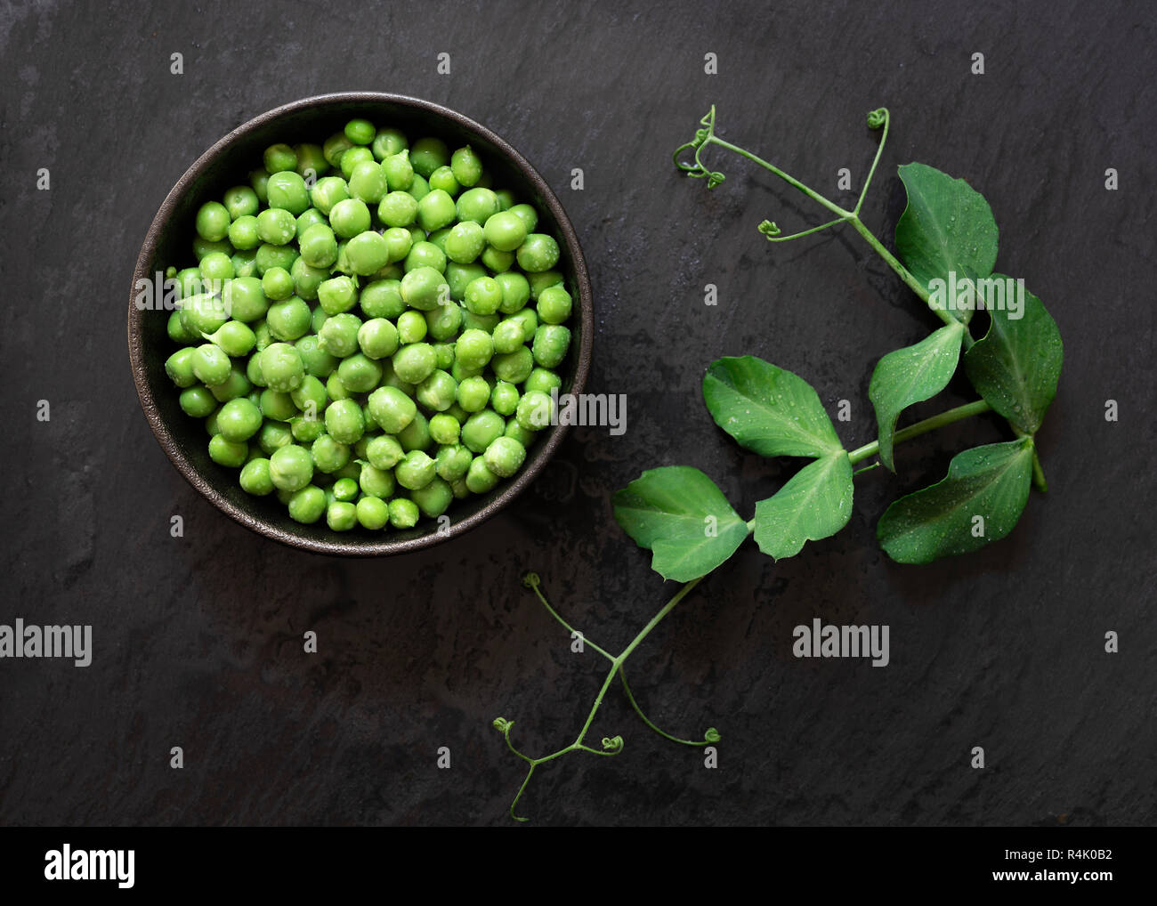 Shelled green peas in a bowl with leaves from the plant Stock Photo - Alamy
