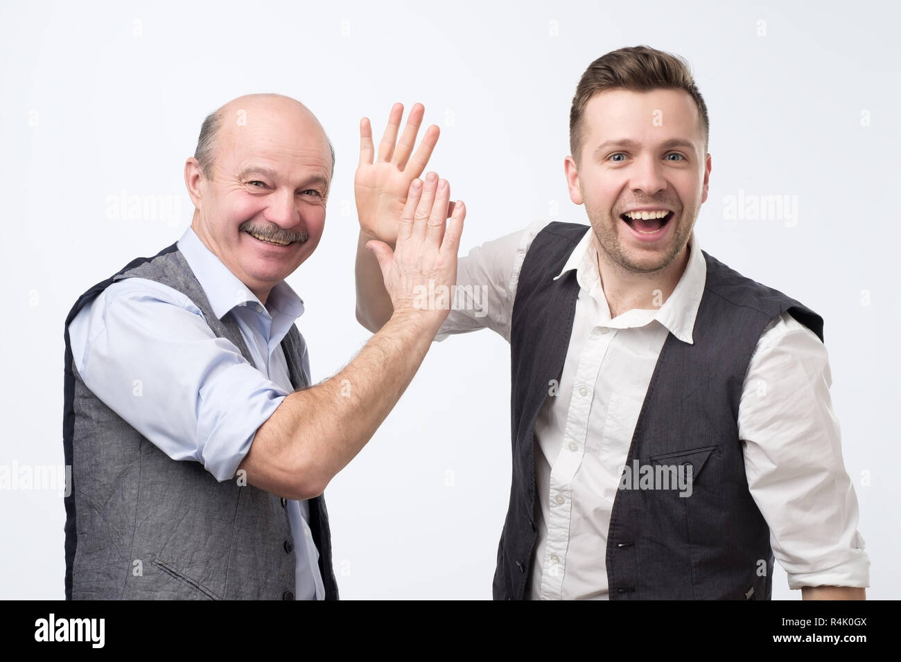 Two cheerful business men clapping each other hands and smiling Stock ...