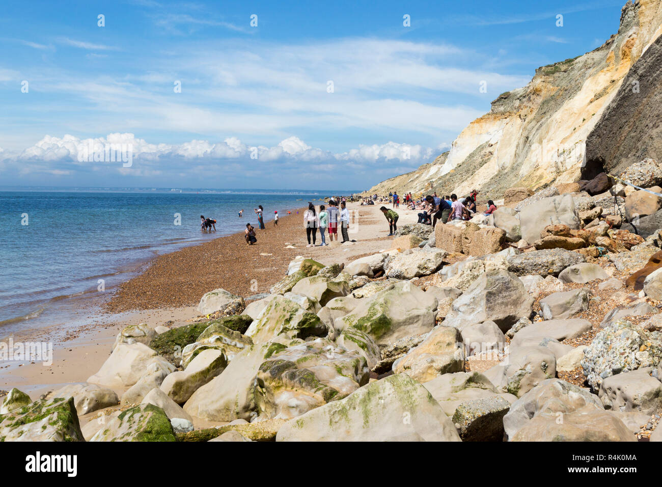 Coastal view / rock strewn beach with eroded & subsiding sandy cliffs ...