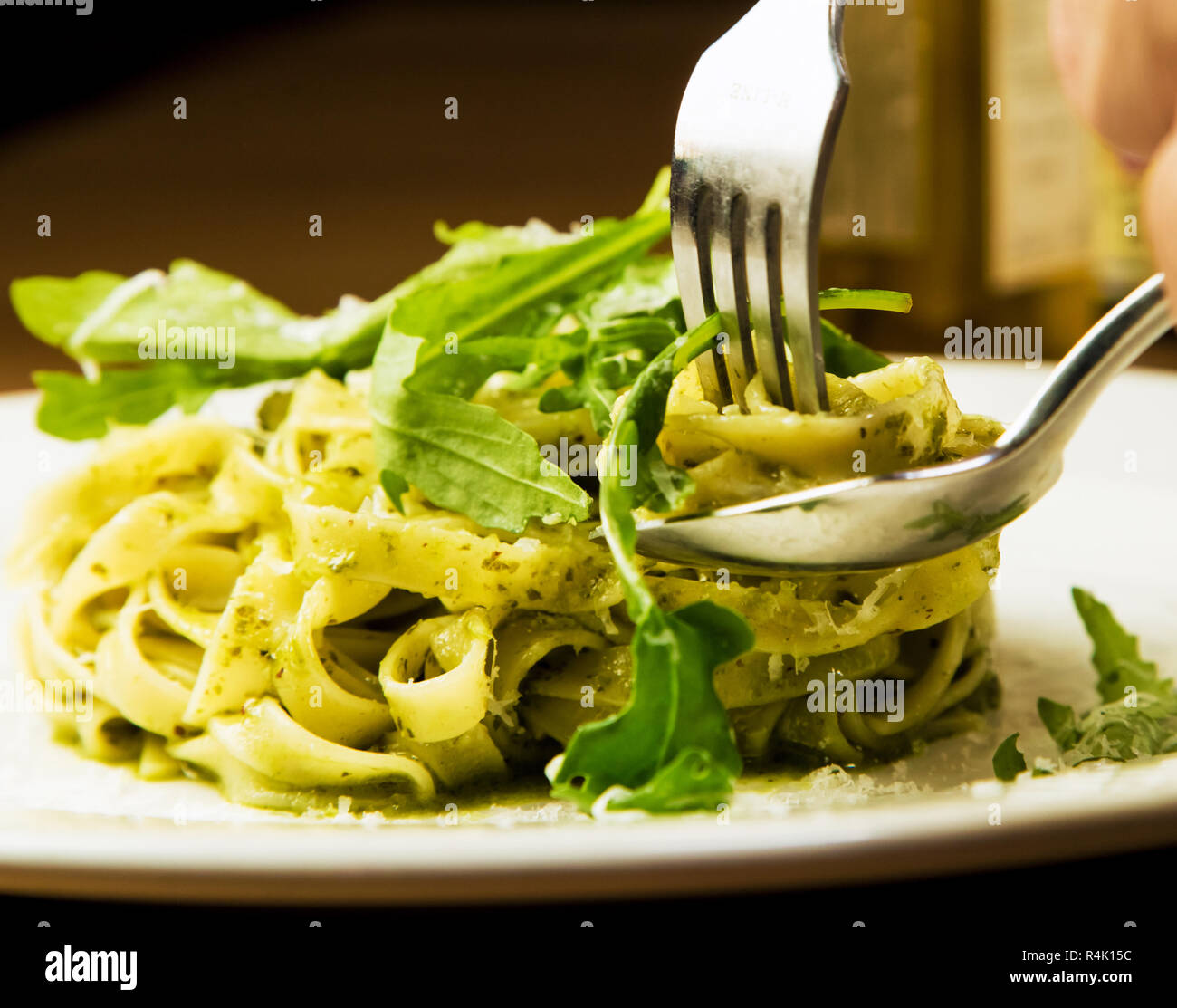 Pesto pasta with fresh rucola on italian restaurant table Stock Photo ...