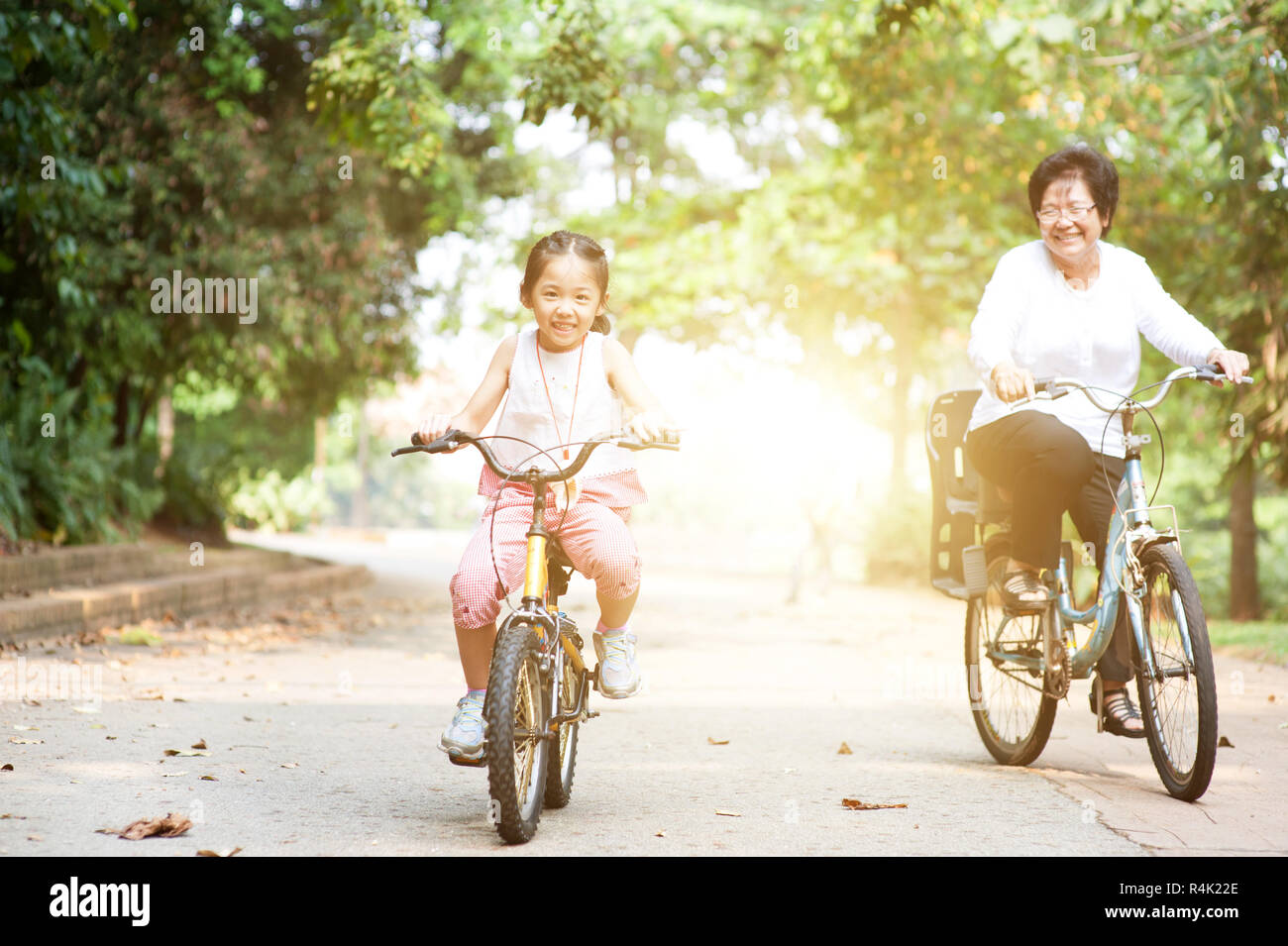Grandmother and granddaughter biking outdoor Stock Photo - Alamy