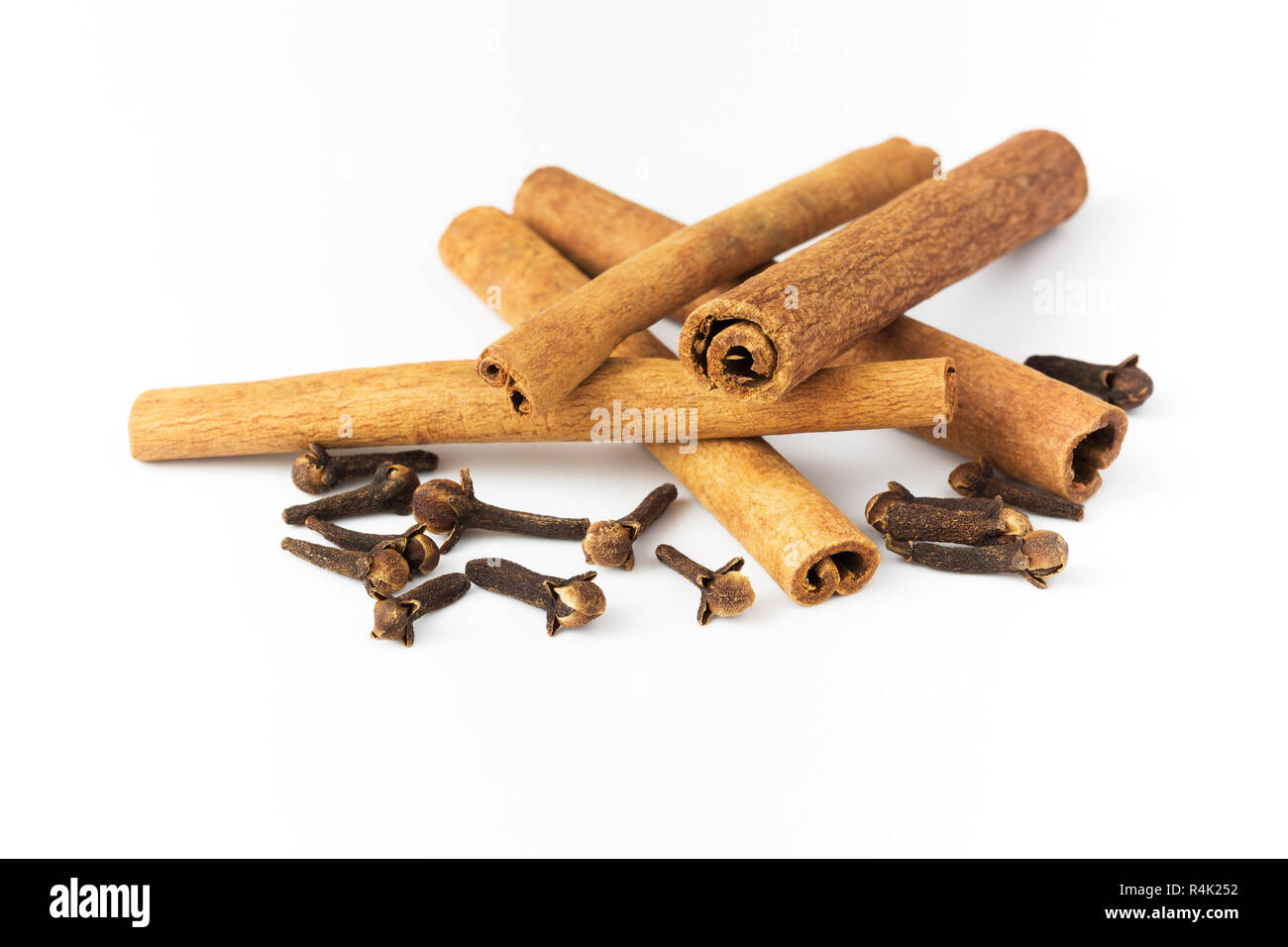 Carnation and cinnamon sticks closeup on a white background. Food and ...