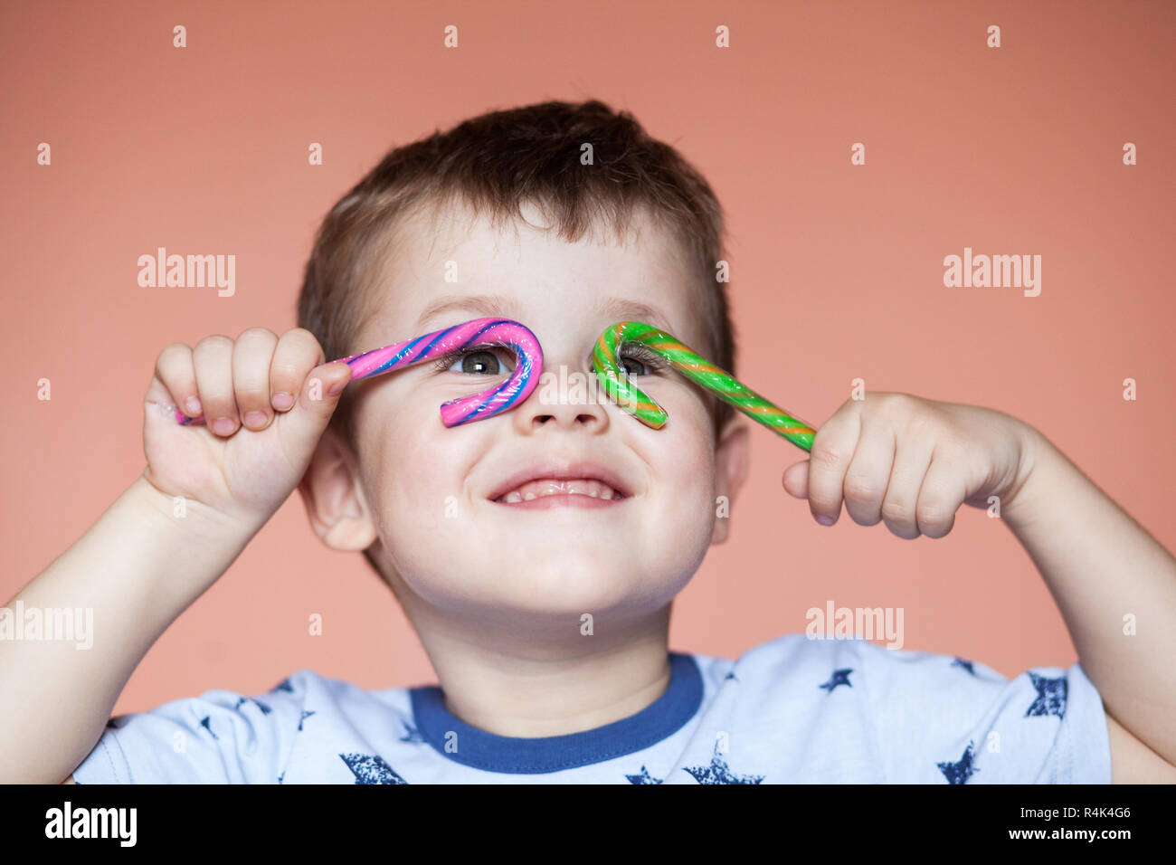 A cute boy holding two candy sticks Stock Photo - Alamy