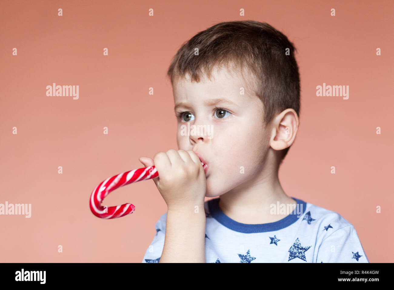 A cute boy eating candy sticks. Colored traditional handmade candy ...