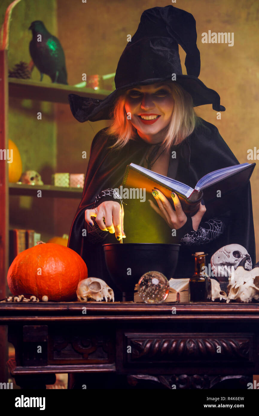 Portrait of witch reading spell over pot of green steam Stock Photo - Alamy