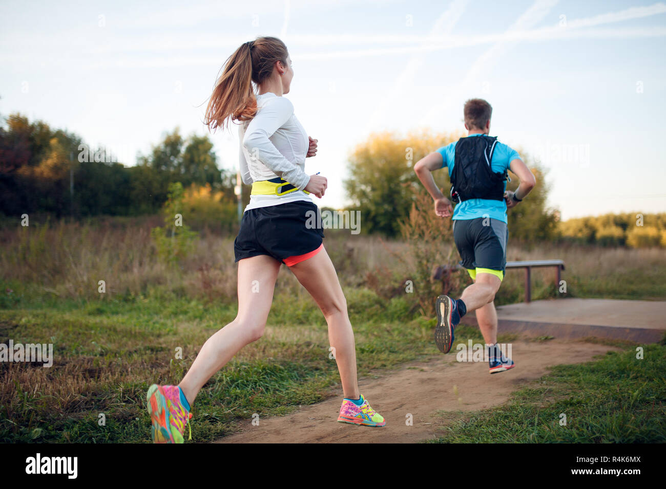 Photo on back of sportive woman and man running through park Stock ...