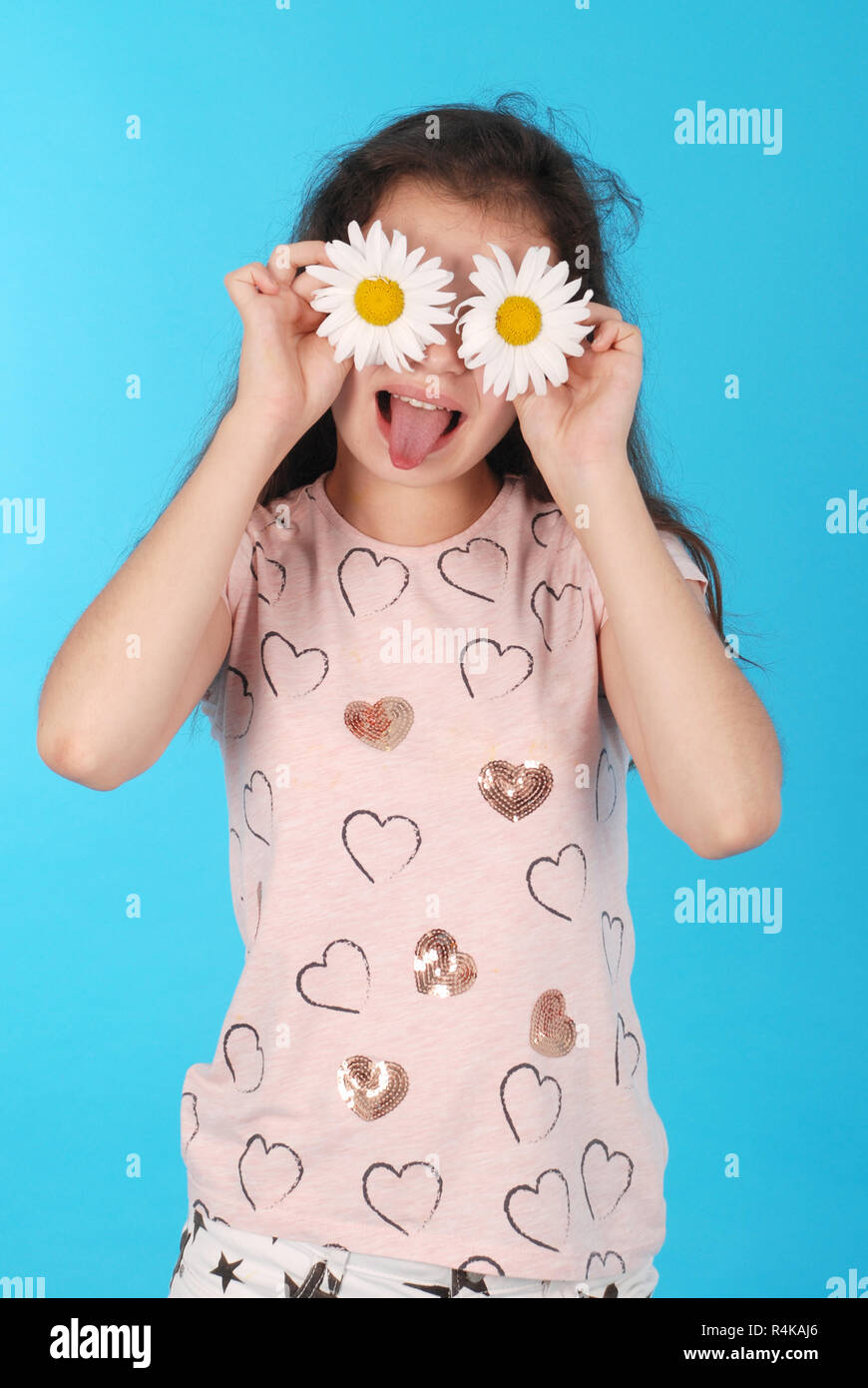 Beautiful young girl with daisy eyes on blue background Stock Photo - Alamy