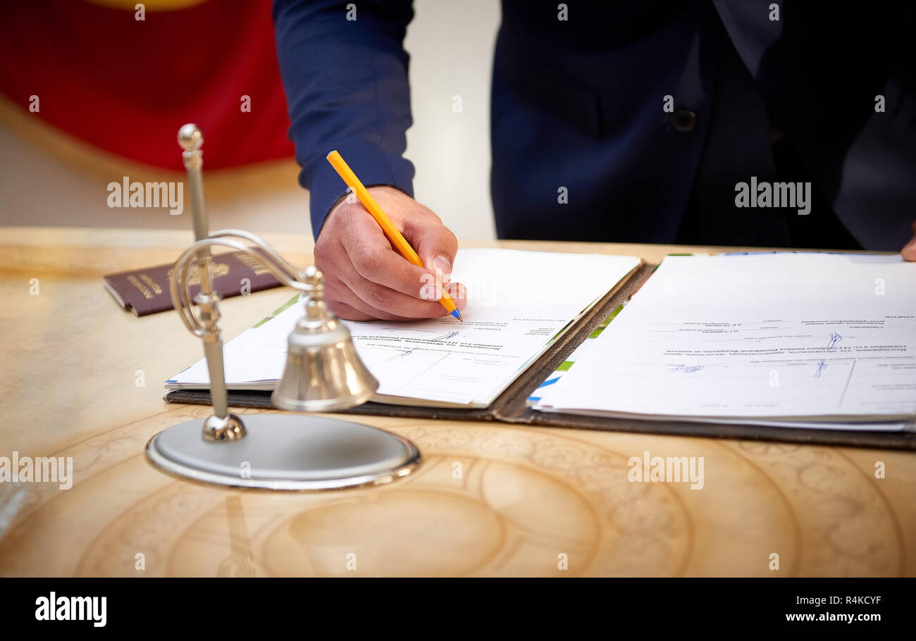 Close-up image of hands of man signing marriage registration form ...