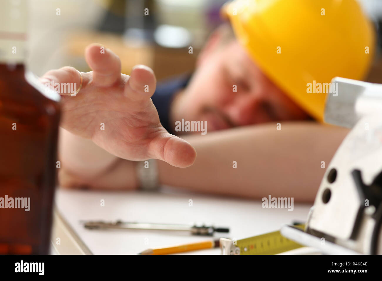 Arm of drunken worker in yellow helmet hold liquor Stock Photo - Alamy