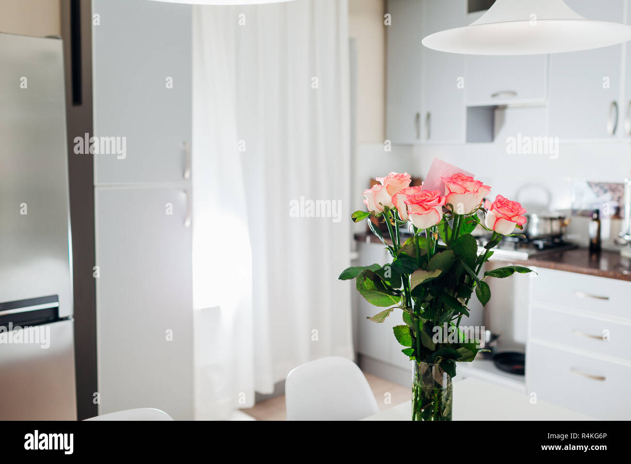 Bouquet of roses with card left on kitchen. Modern kitchen design ...