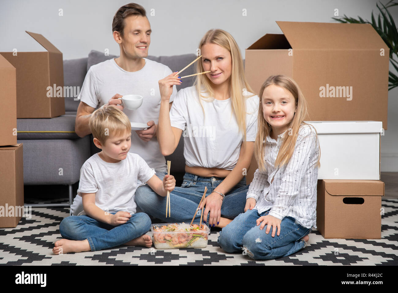 Picture of young couple with children eating rice with shrimps sitting ...