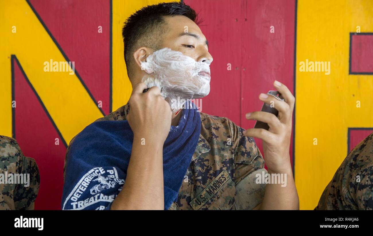 A U.S. Marine with 3rd Marine Regiment, 3rd Marine Division shaves off ...
