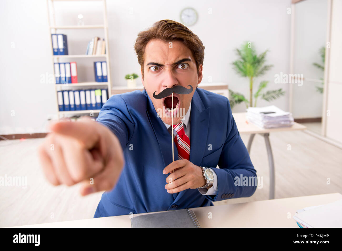 Funny bisinessman with fake moustache in the office Stock Photo - Alamy