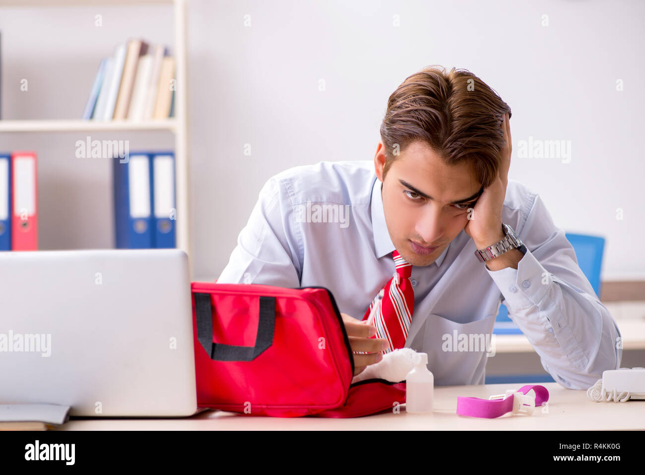 Man with first aid kit in the office Stock Photo - Alamy