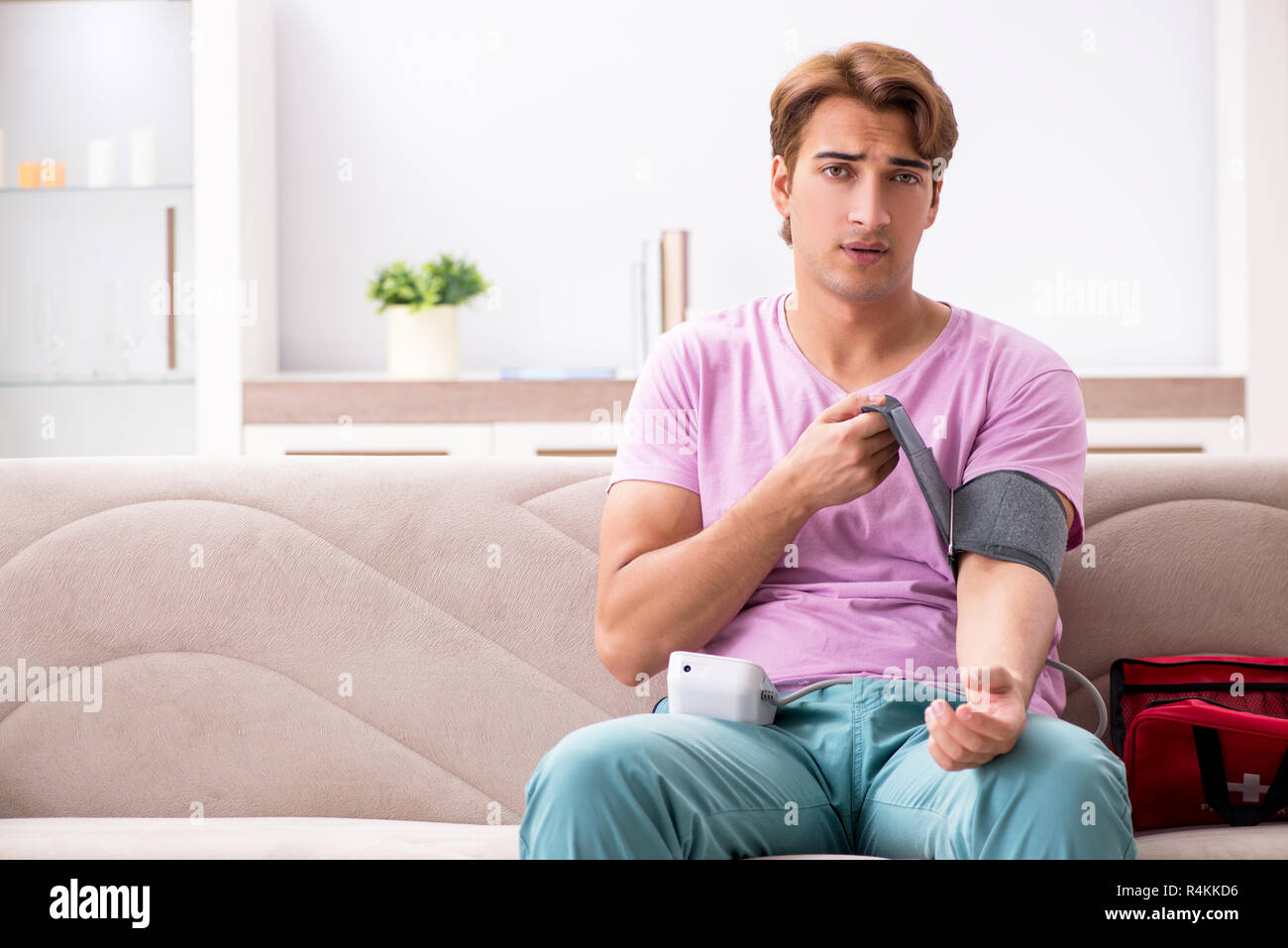 Sick man at home with first aid kit Stock Photo - Alamy