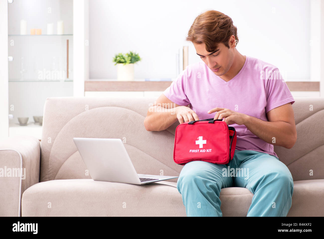 Sick man at home with first aid kit Stock Photo - Alamy