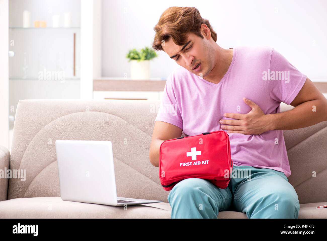 Sick man at home with first aid kit Stock Photo - Alamy