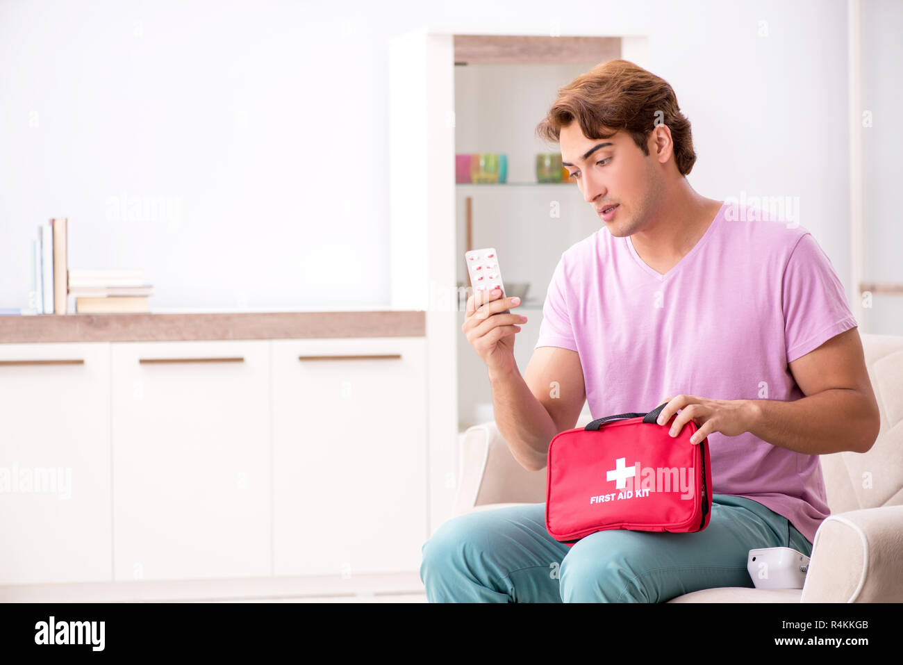 Sick man at home with first aid kit Stock Photo - Alamy