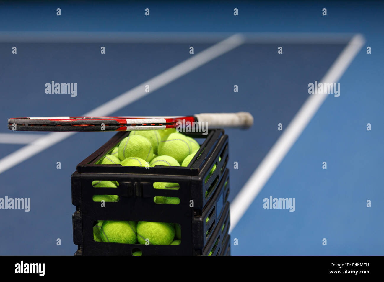 Box with tennis balls and tennis racket on tennis court Stock Photo - Alamy