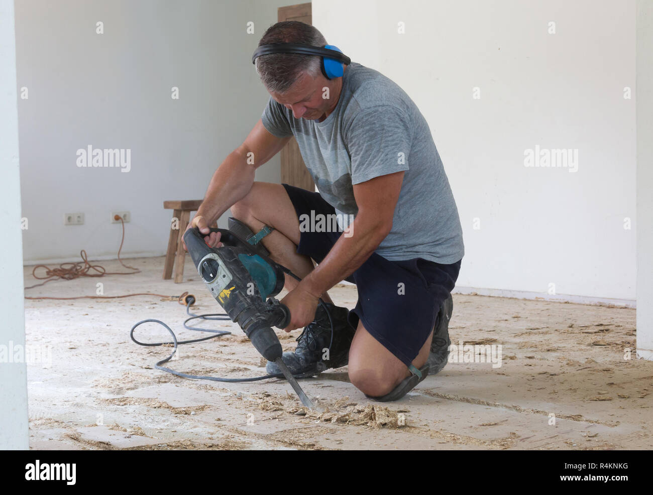 Construction concept - Jackhammer, removing chipboard from the floor ...