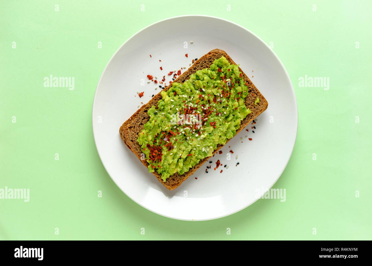 Healthy smashed avocado and chilli flakes on rye bread and a white ...