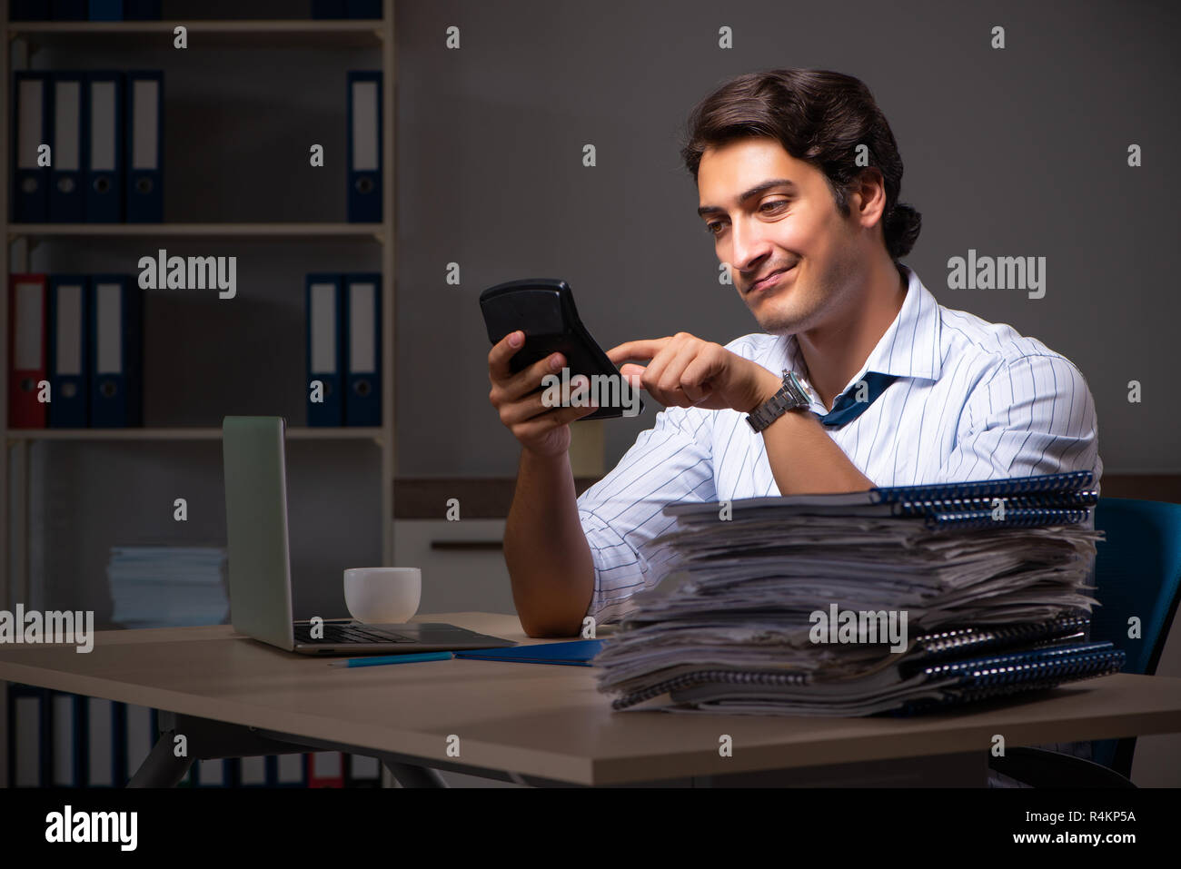 Young financial manager working late at night in office Stock Photo - Alamy
