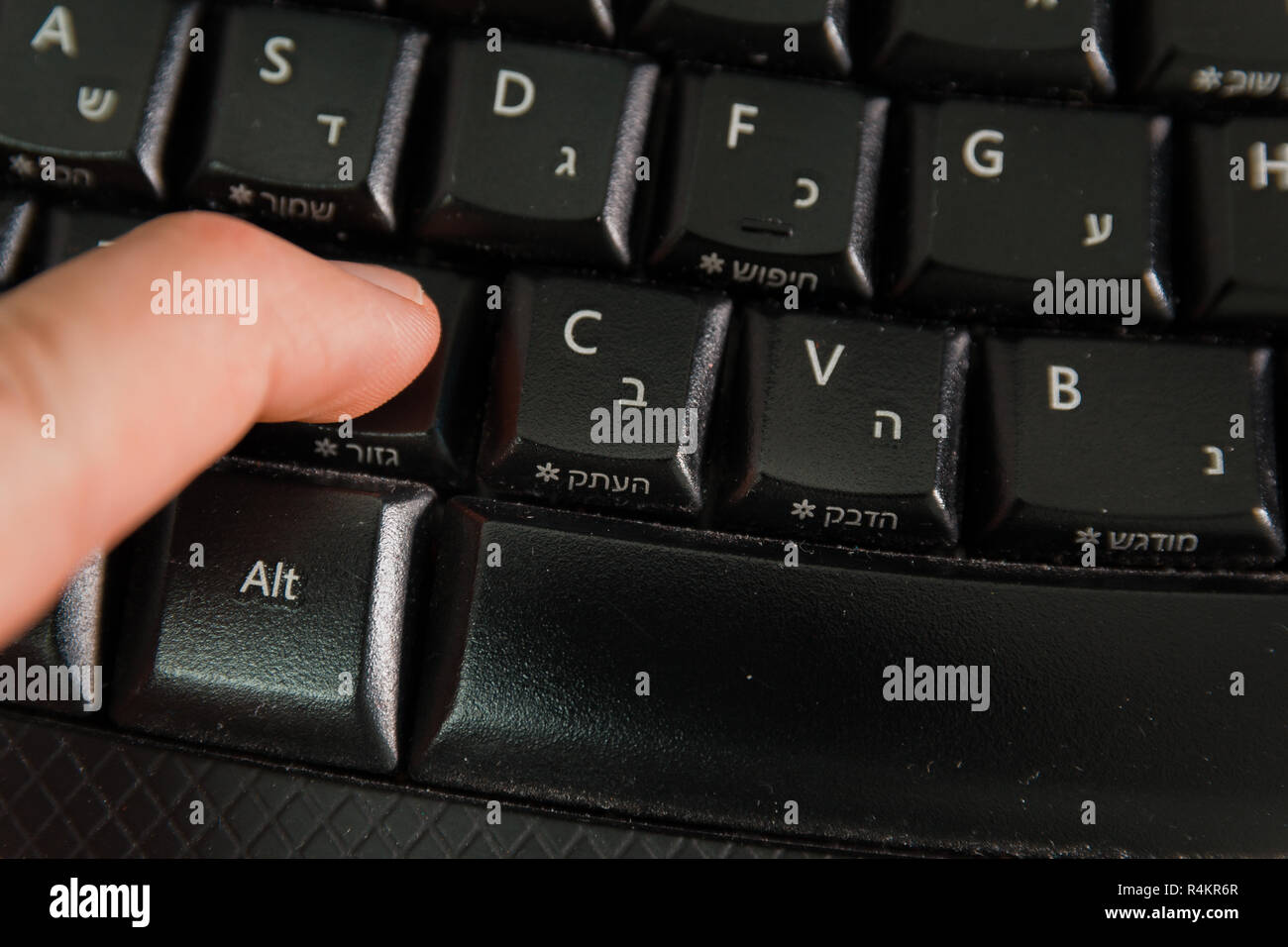 Man typing on a keyboard with letters in Hebrew and English Stock Photo ...