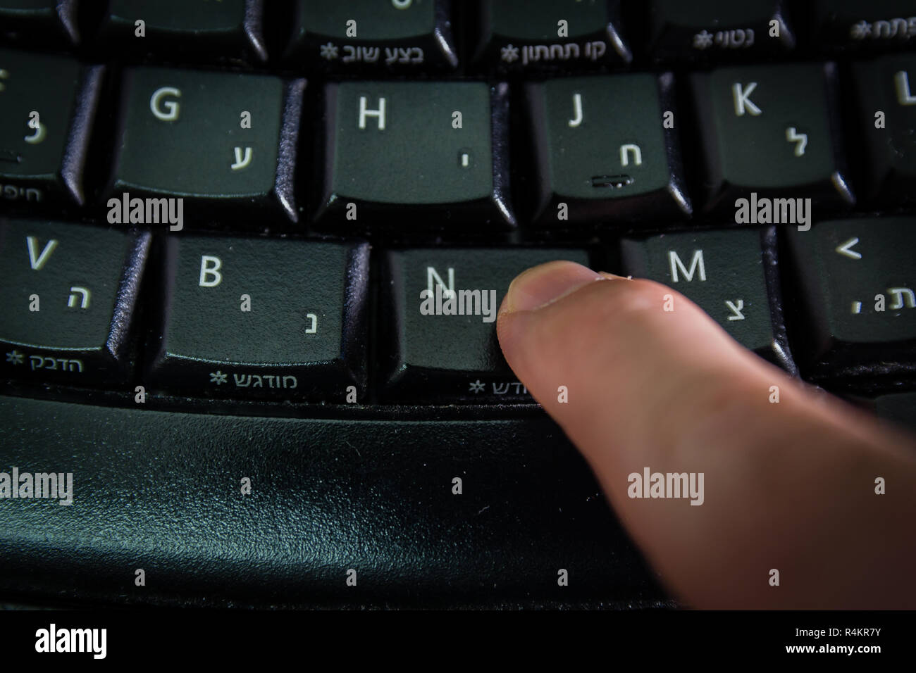 Man typing on a keyboard with letters in Hebrew and English Stock Photo ...