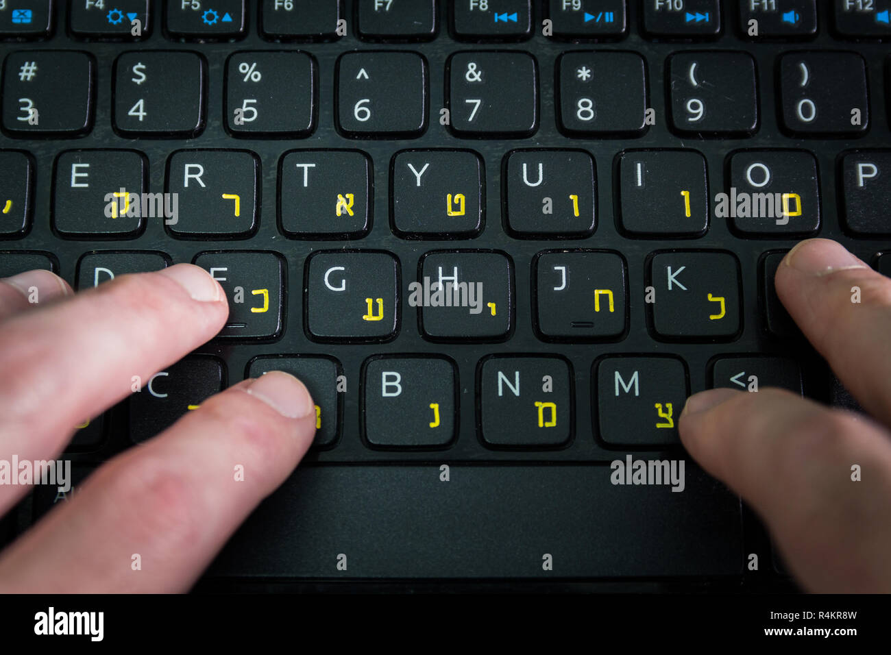 Man typing on a keyboard with letters in Hebrew and English Stock Photo ...