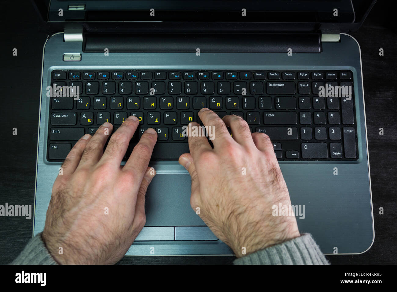 Man typing on a keyboard with letters in Hebrew and English Stock Photo ...