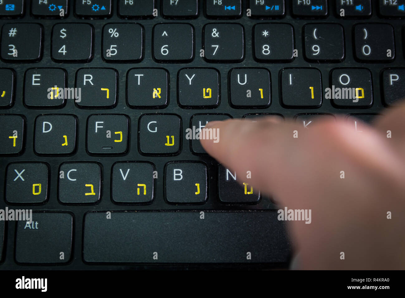Man typing on a keyboard with letters in Hebrew and English Stock Photo ...