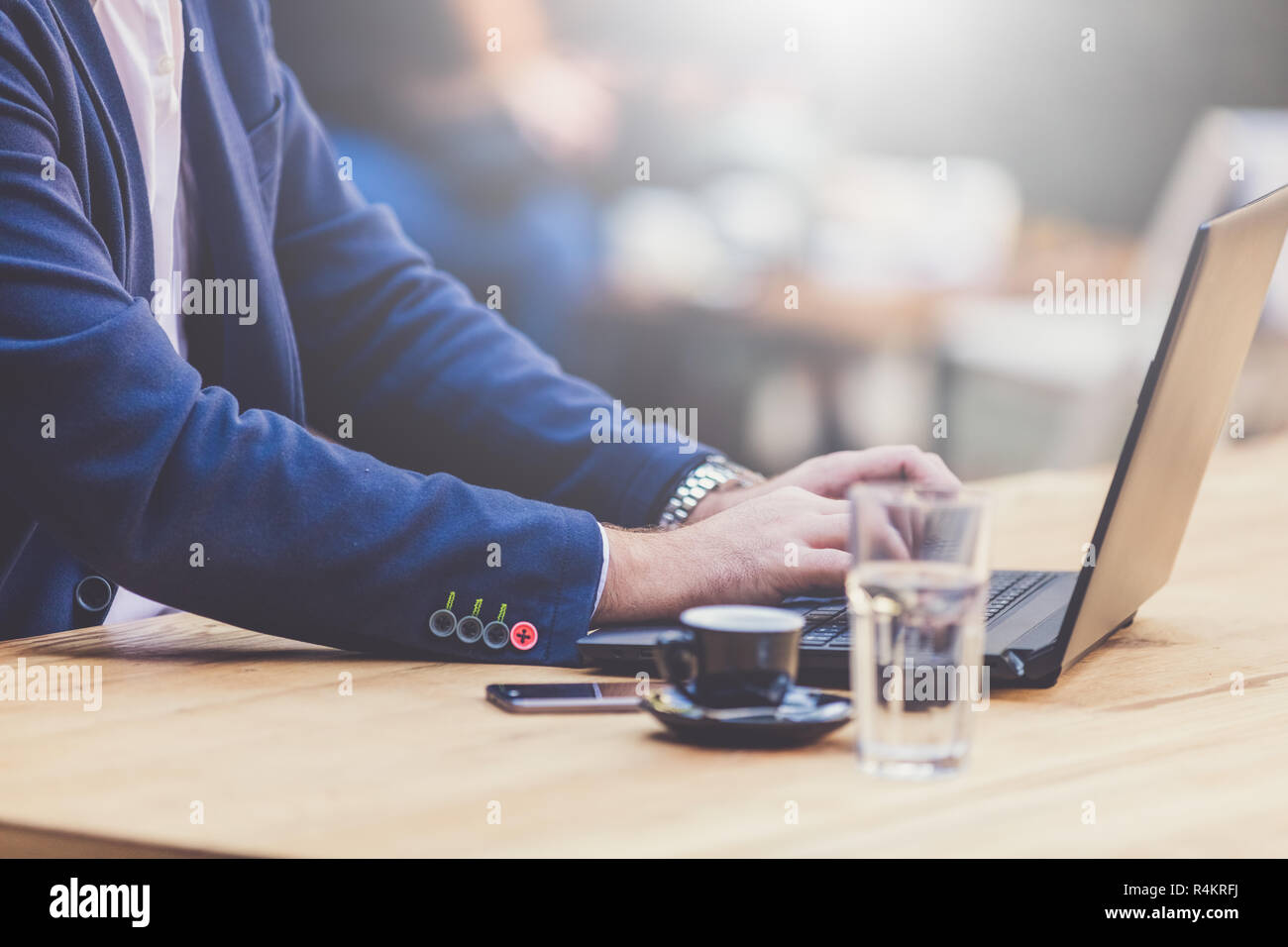 Close up of businessman hands on laptop keyboard in cafe. Space for ...