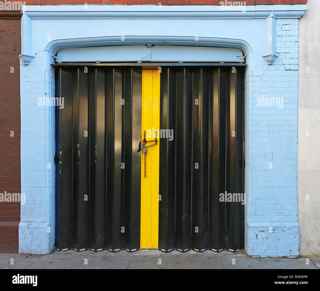 Closed black accordion doors locked with padlock and chain hi-res stock ...