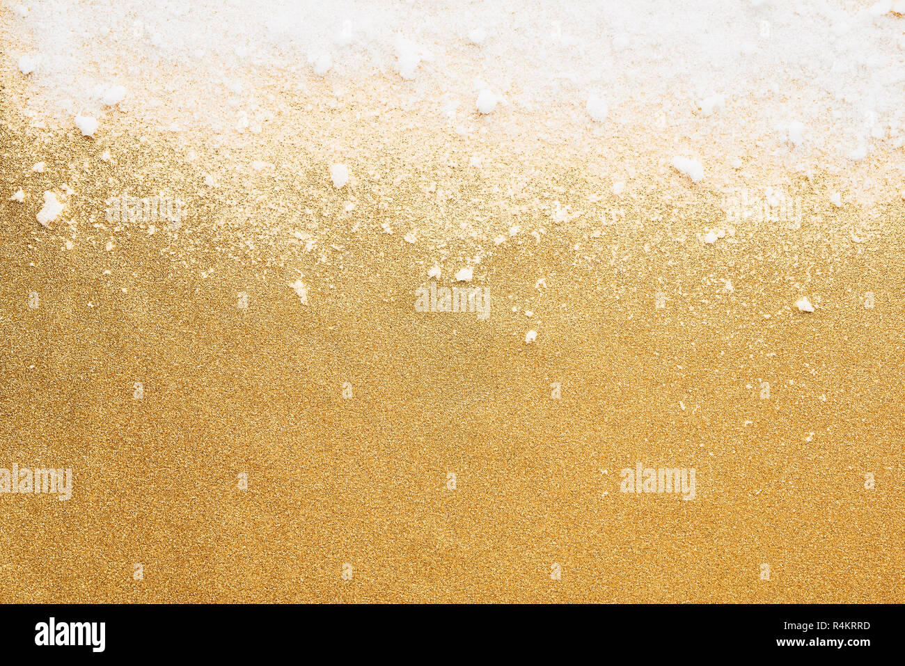 White powdery snow on golden glitter background. Snow and glitter for ...