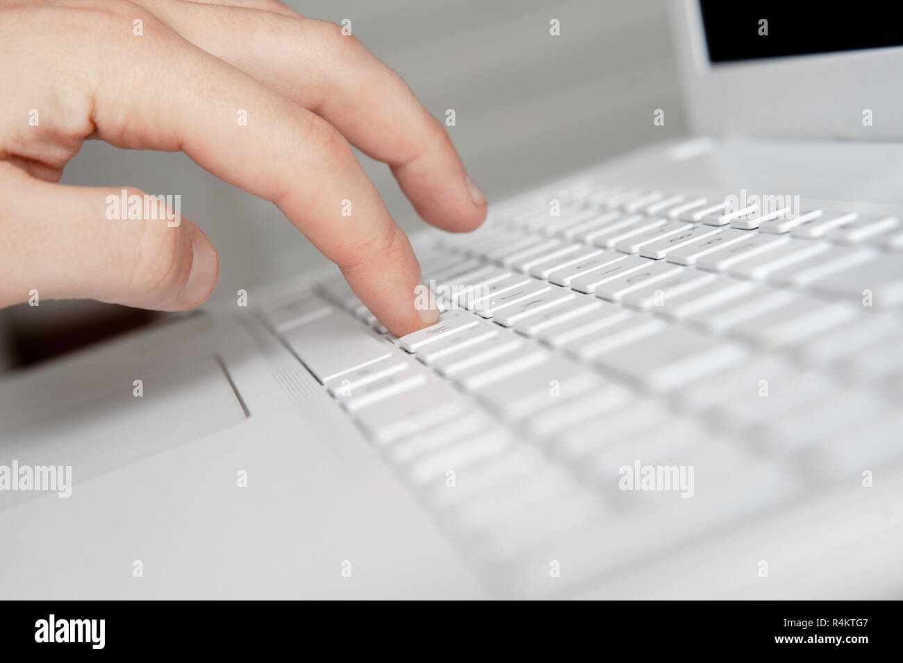 mans hand typing on white keyboard by fingers. white style workspace ...