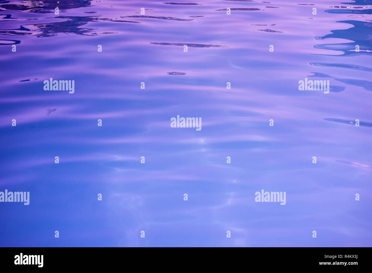 ultraviolet water of pool or sea with waves and sunlight glares at ...