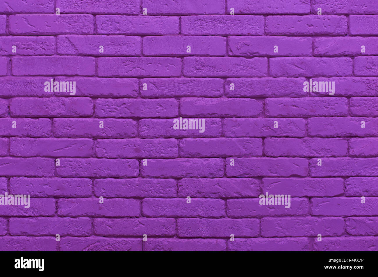 ultraviolet brick wall painted at saturated purple colour. closeup ...