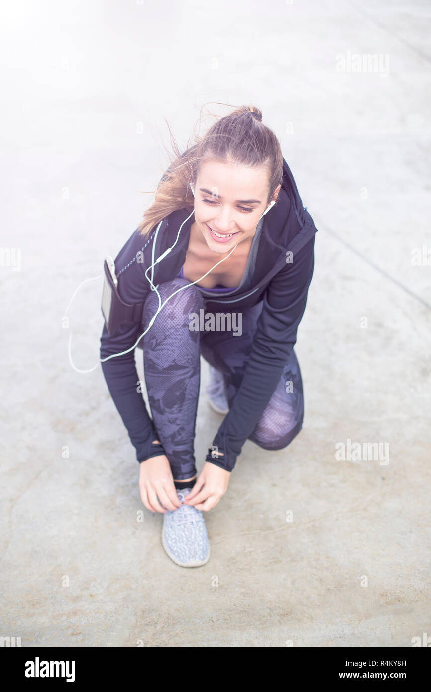 Top view at sporty woman tying shoelace on running shoes before ...