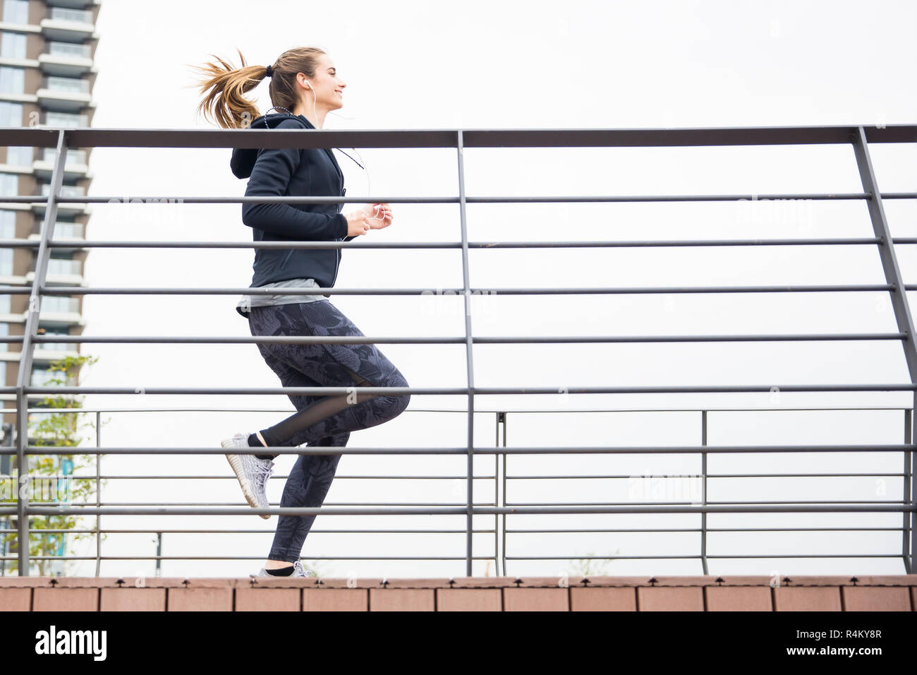 Young woman jumping fence hi-res stock photography and images - Alamy