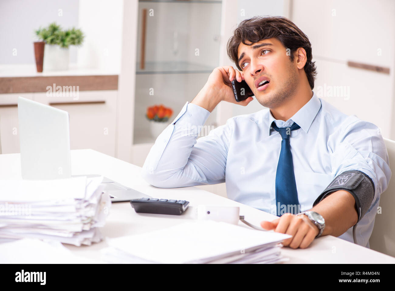 Man under stress measuring his blood pressure Stock Photo - Alamy