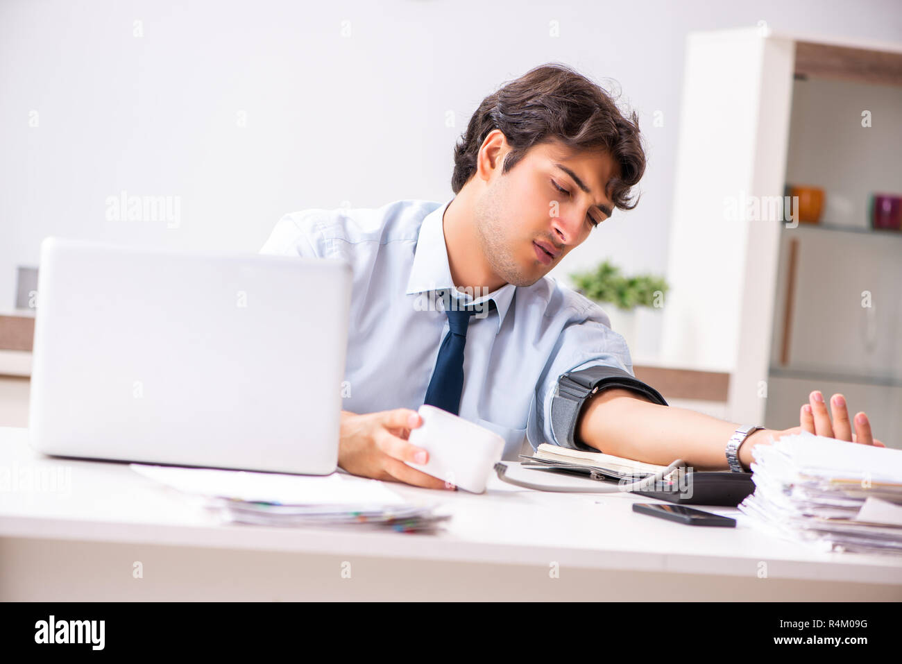 Man under stress measuring his blood pressure Stock Photo - Alamy