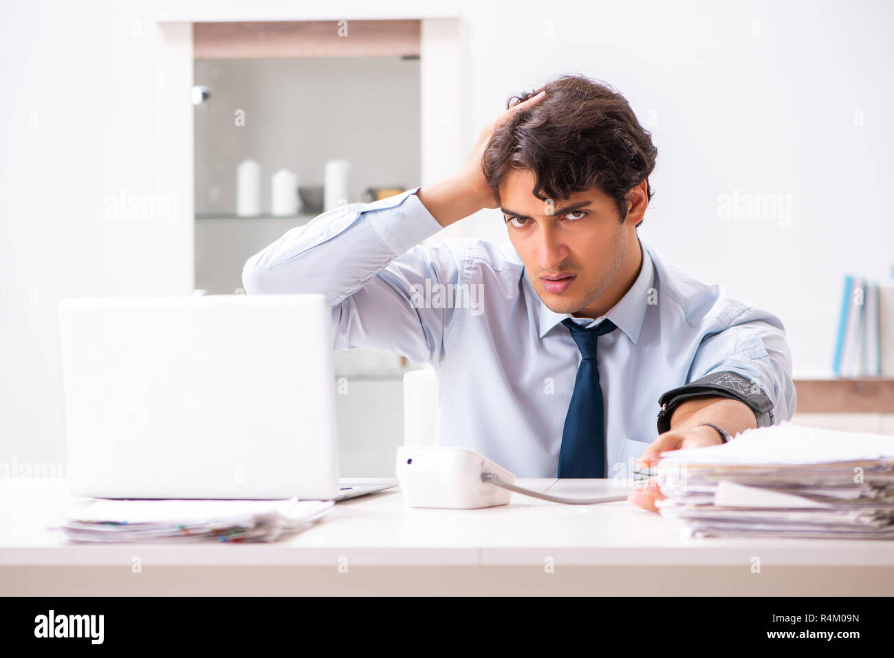 Man under stress measuring his blood pressure Stock Photo - Alamy