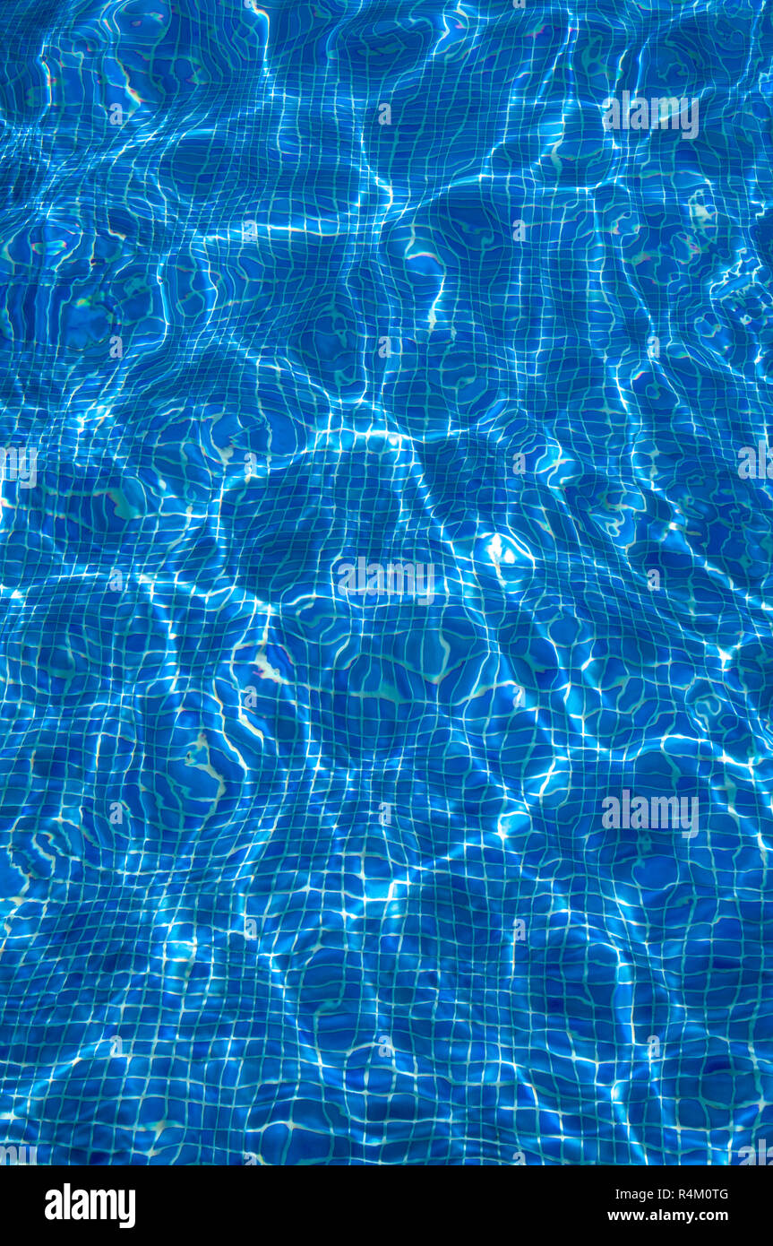 Detail of mosaic tile floor in a swimming pool seen through rippled ...