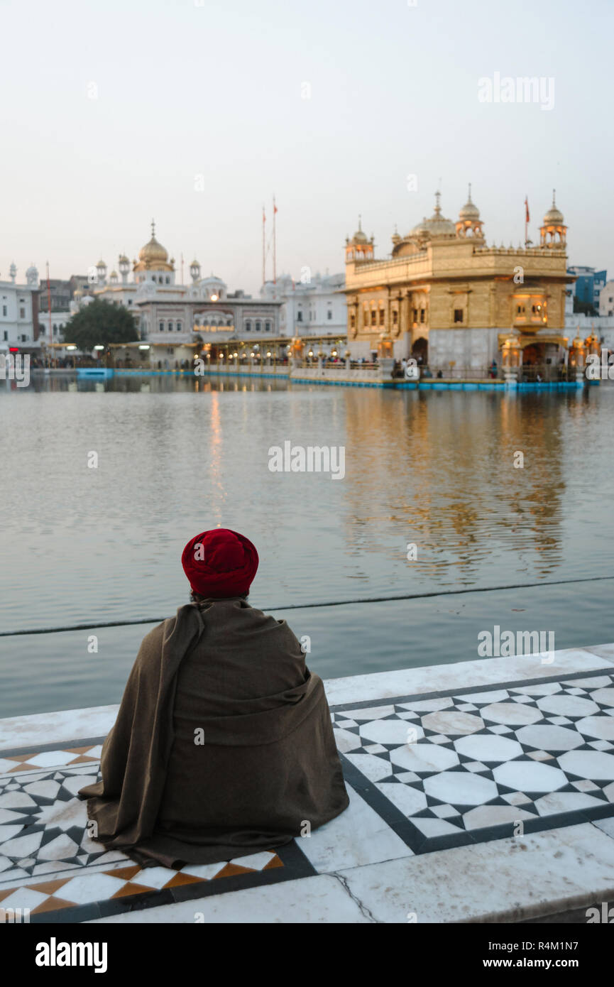 alone indian sikh man sits near the water of Golden Temple. 24 february ...