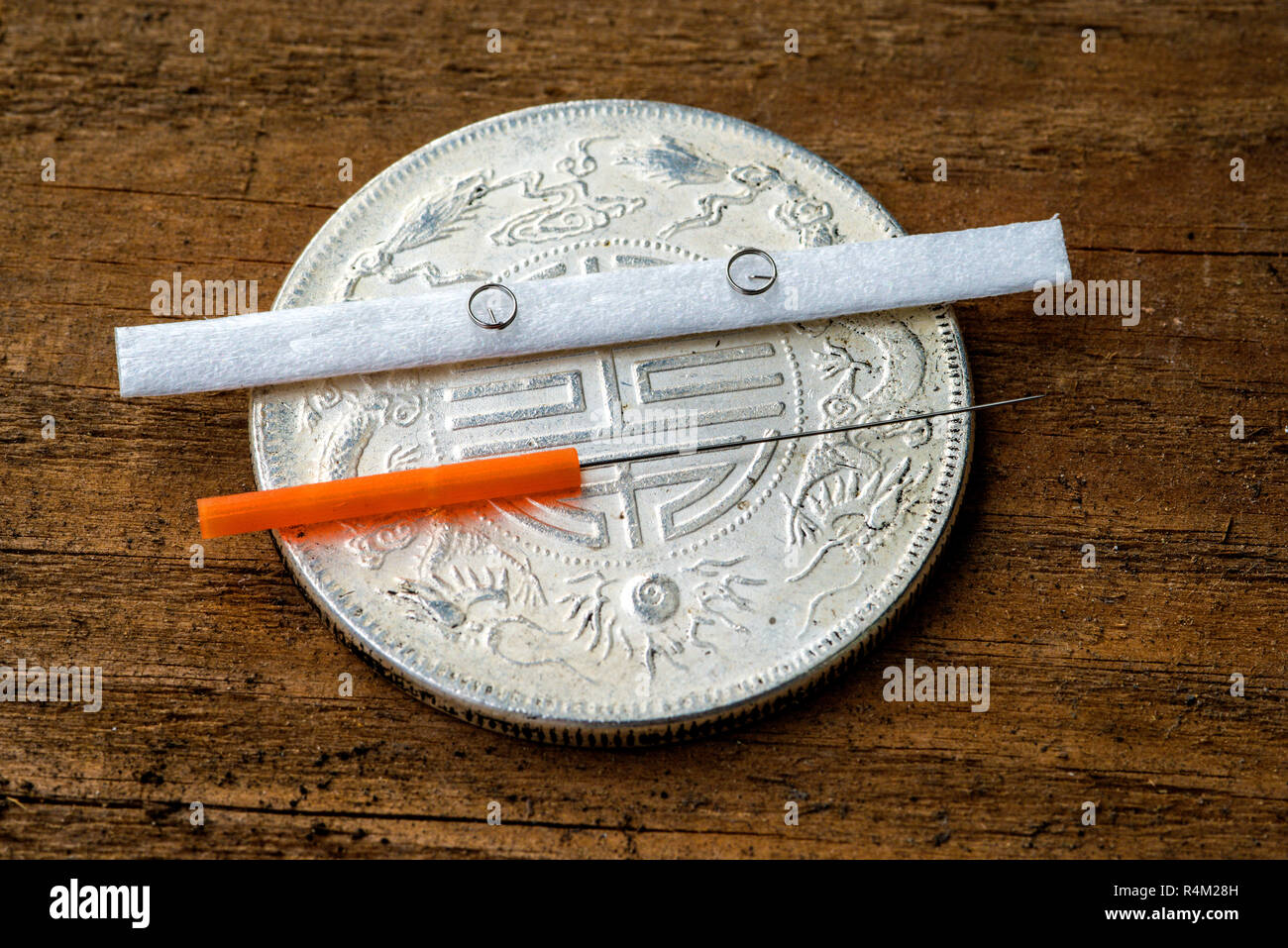 acupuncture needle on antique chinese coin Stock Photo - Alamy