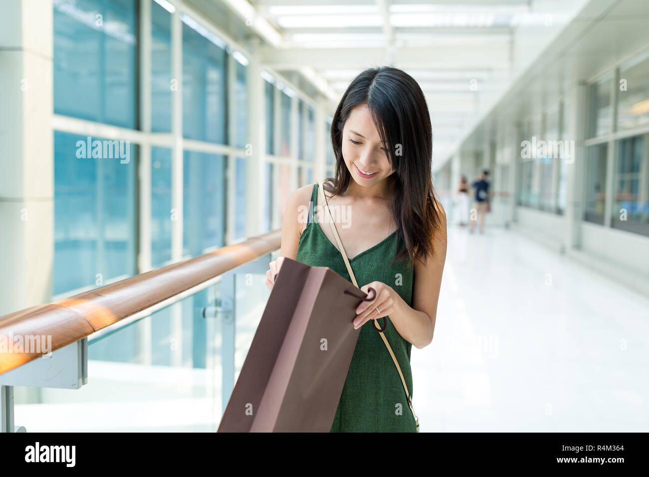 Young woman looking into shopping bag Stock Photo - Alamy
